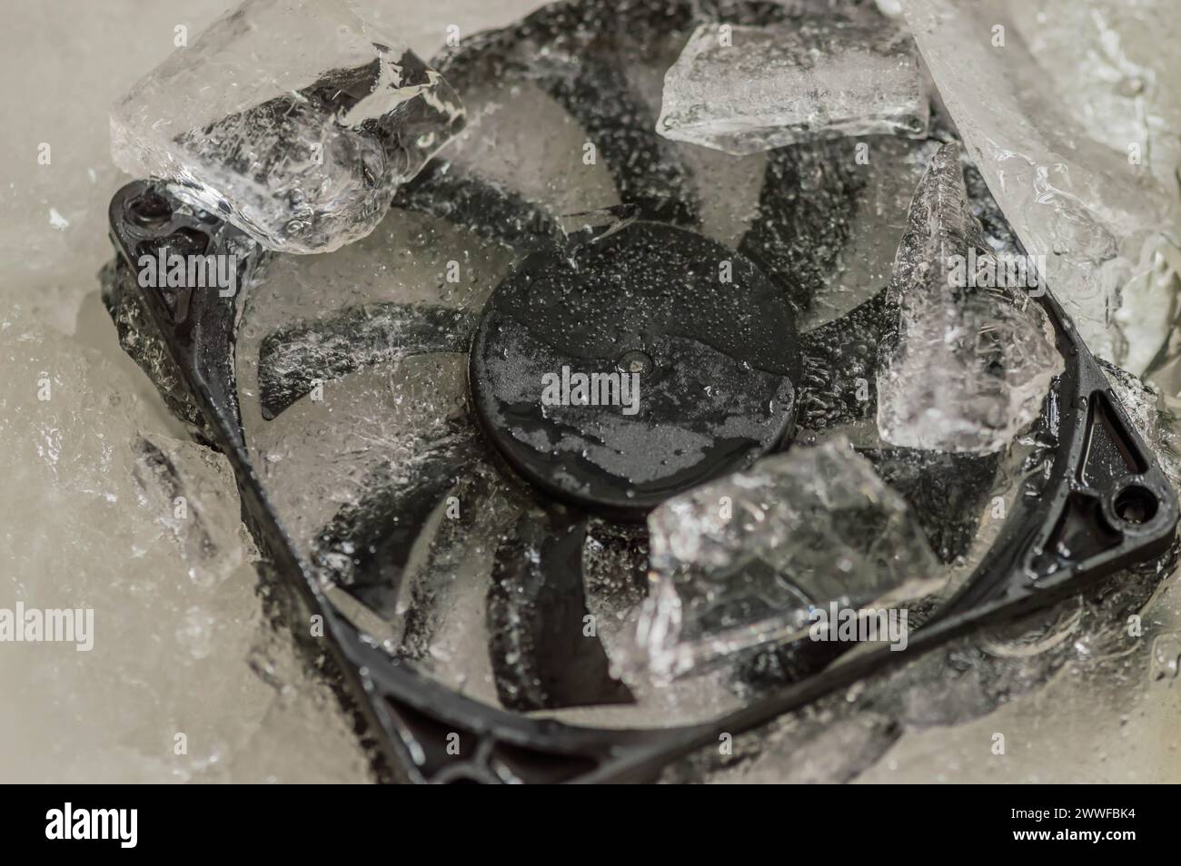 Closeup of computer case fan frozen in block of ice. Concept keep your ...