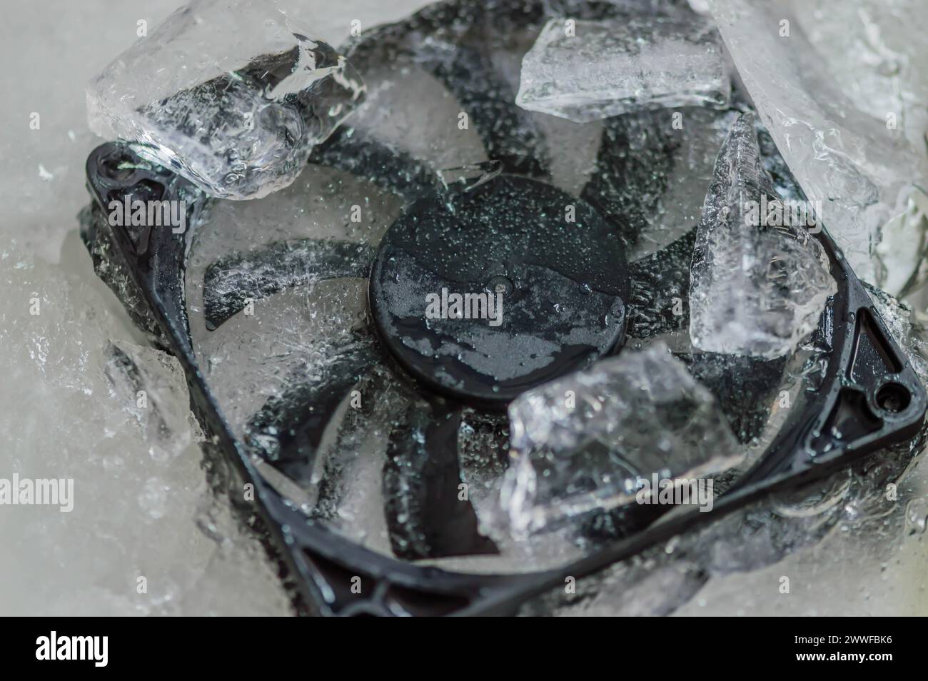 Closeup of computer case fan frozen in block of ice. Concept keep your ...