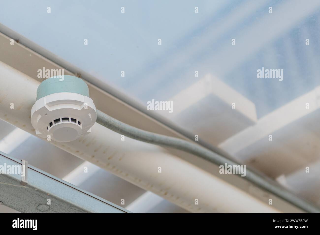 Electronic smoke detector on ceiling of enclosed pedestrian walkway ...