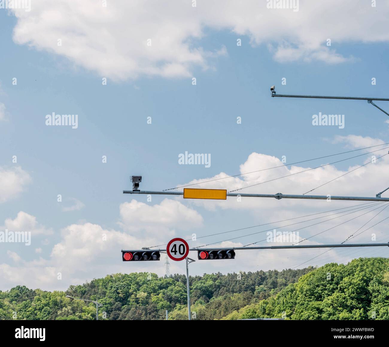 Traffic lights and a blank road sign against a clear sky with a 40 km/h ...
