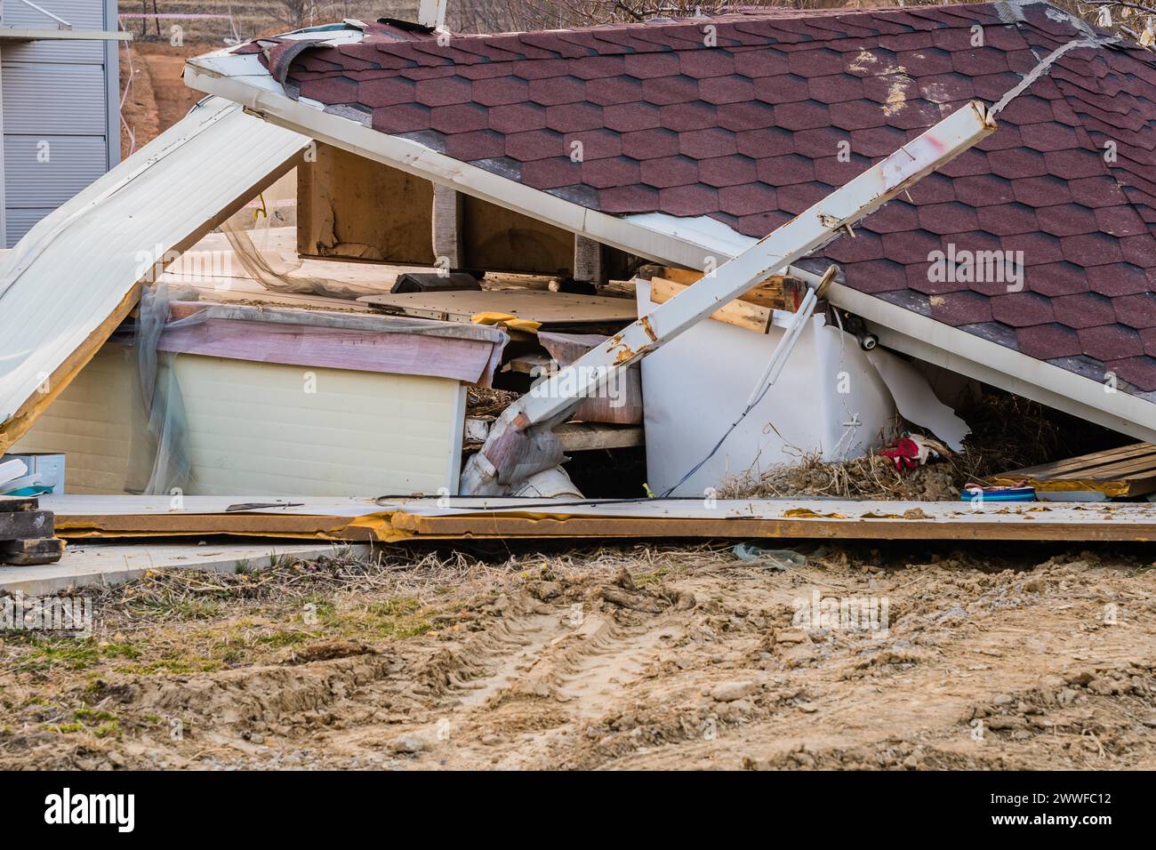 Partially collapsed building with a destroyed roof and scattered debris ...