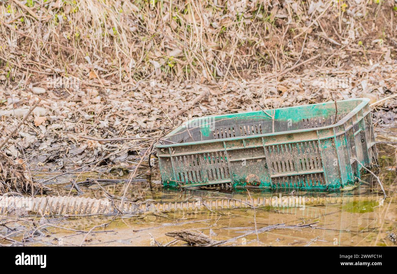 A green plastic crate abandoned in a muddy puddle, in South Korea Stock ...