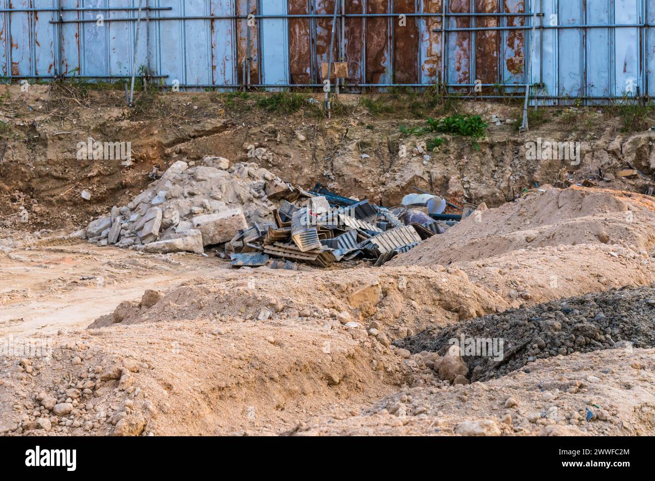 Construction site with debris, scaffolding, and piles of dirt under a ...