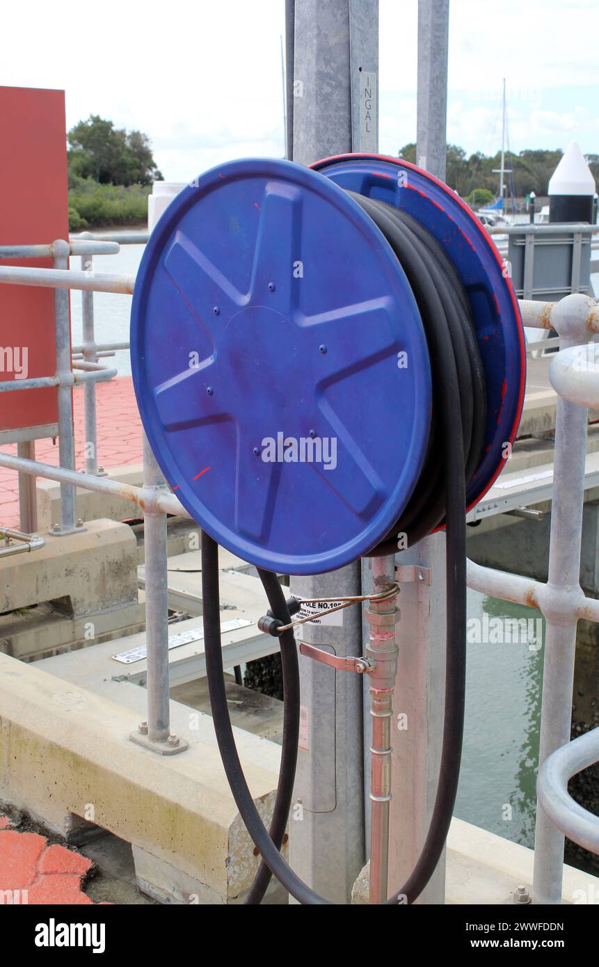 Black hose wrapped around a blue hose reel Stock Photo - Alamy