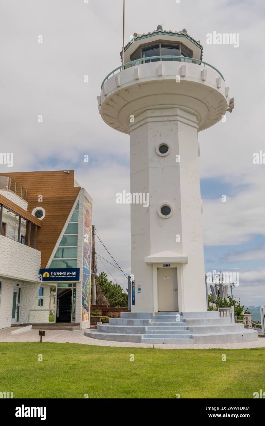A white lighthouse with a circular balcony against a blue sky, in Ulsan ...