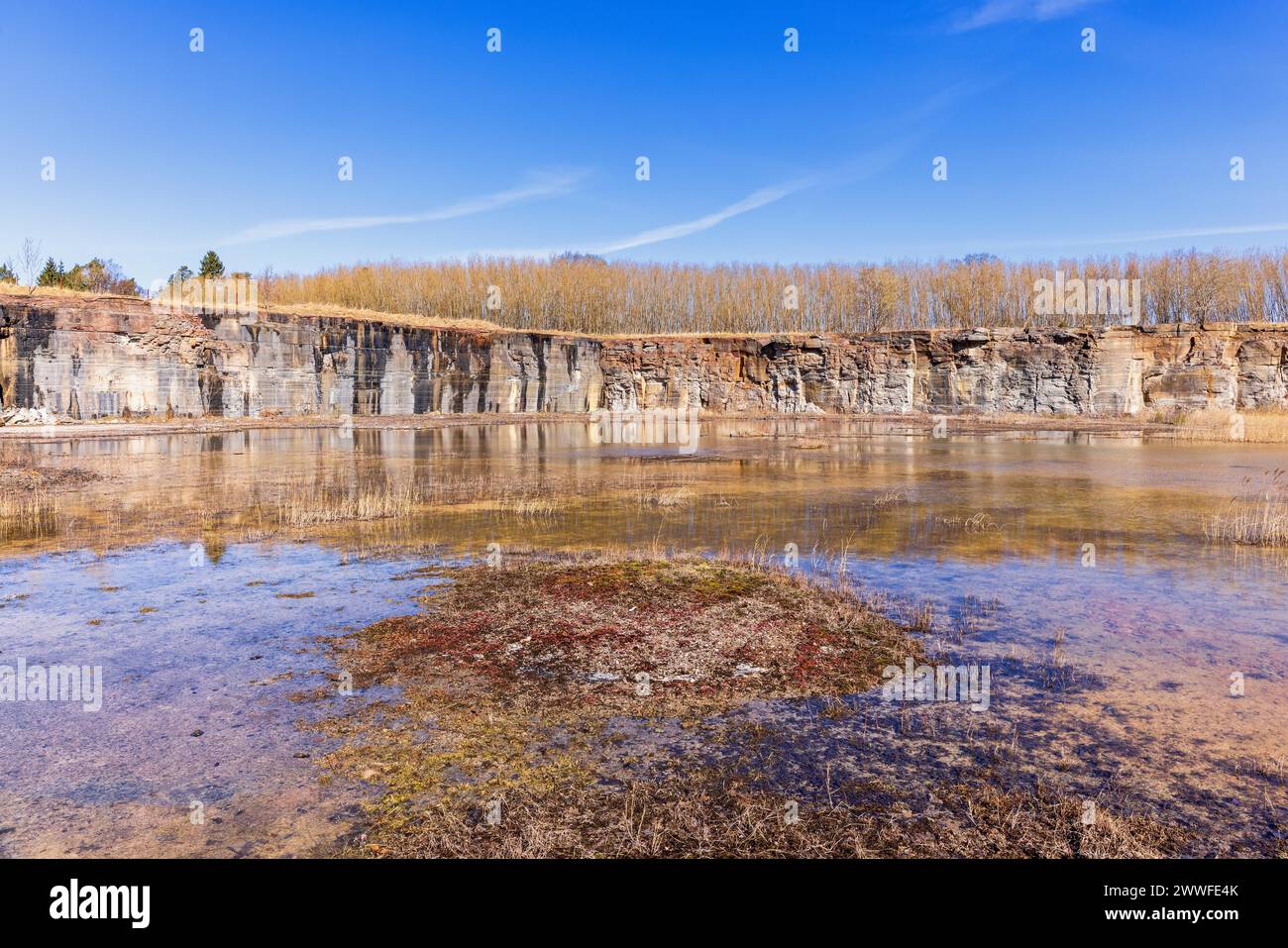 Old disused limestone quarry with water reflections on the ground at ...