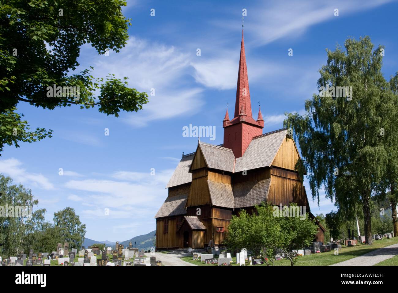 A traditional Norwegian stave church with a red roof under a clear blue ...