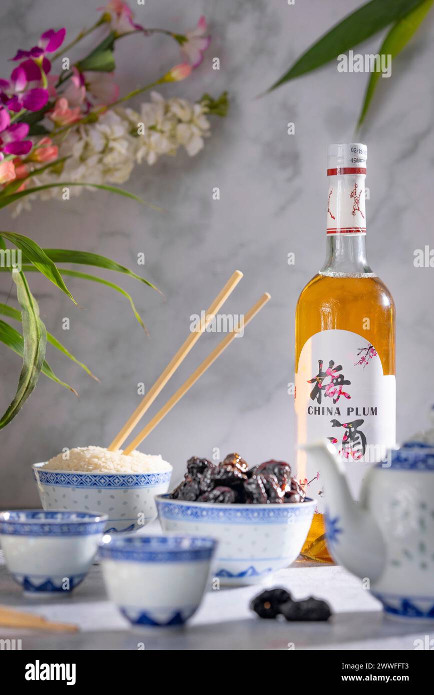 Asian tea set with blue patterns, a bottle of Chinese plum wine, dried ...