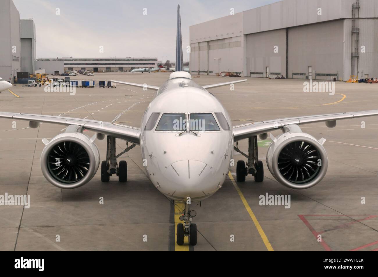 Front view of a modern twinjet airliner sitting on the concrete tarmac ...