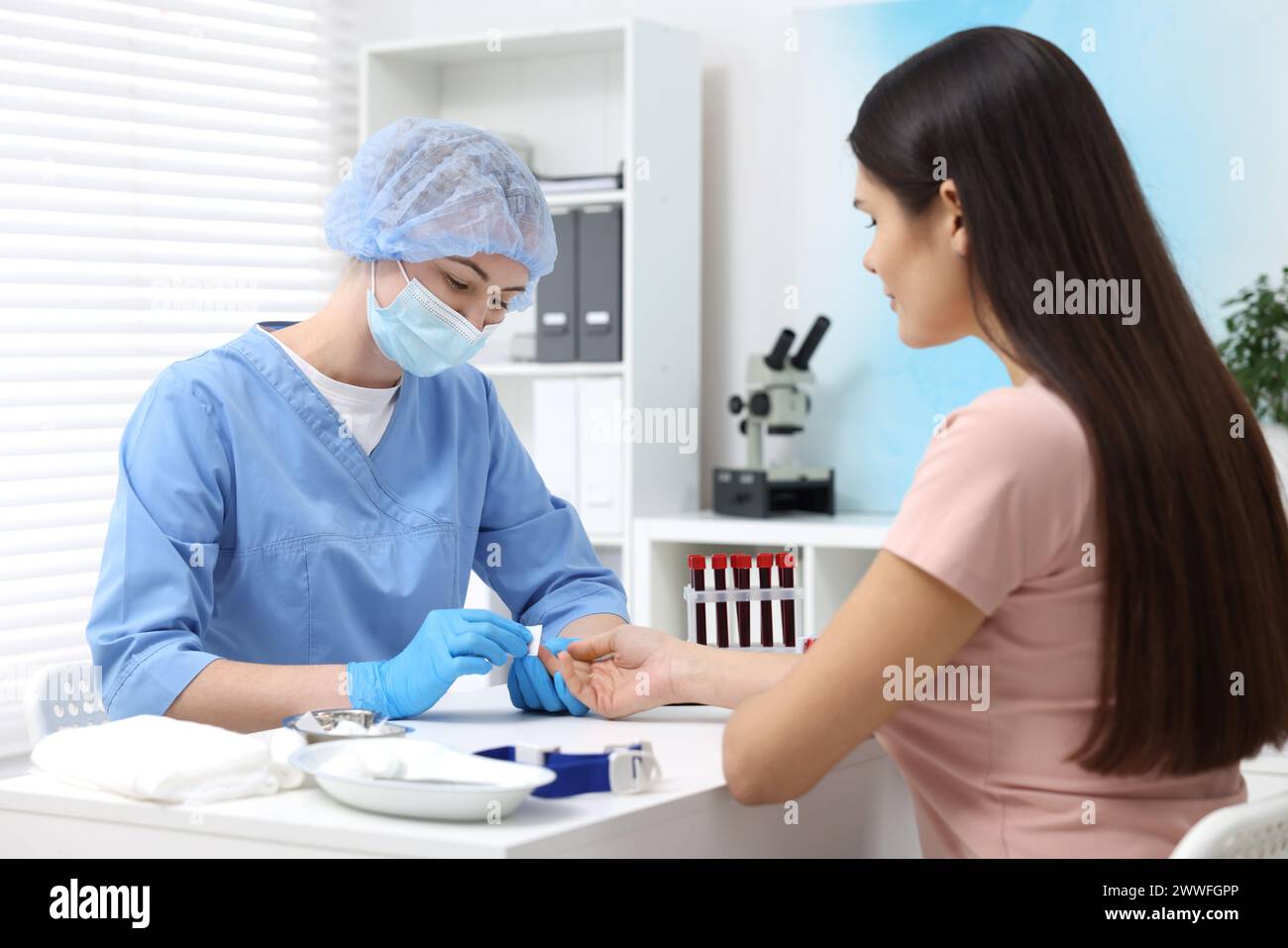 Laboratory testing. Doctor taking blood sample from patient at white ...