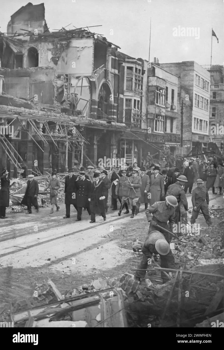 A photograph shows King George VI walking through the damaged streets ...
