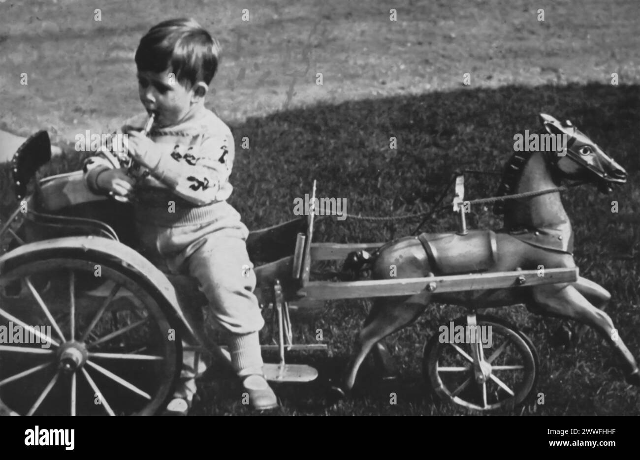 A photograph of a young Charles III is shown playing with his toy ...