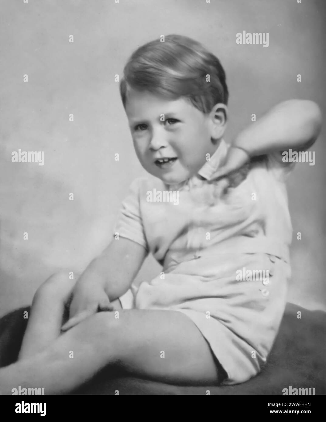 A young Charles III is shown seated, posing for the camera in a ...