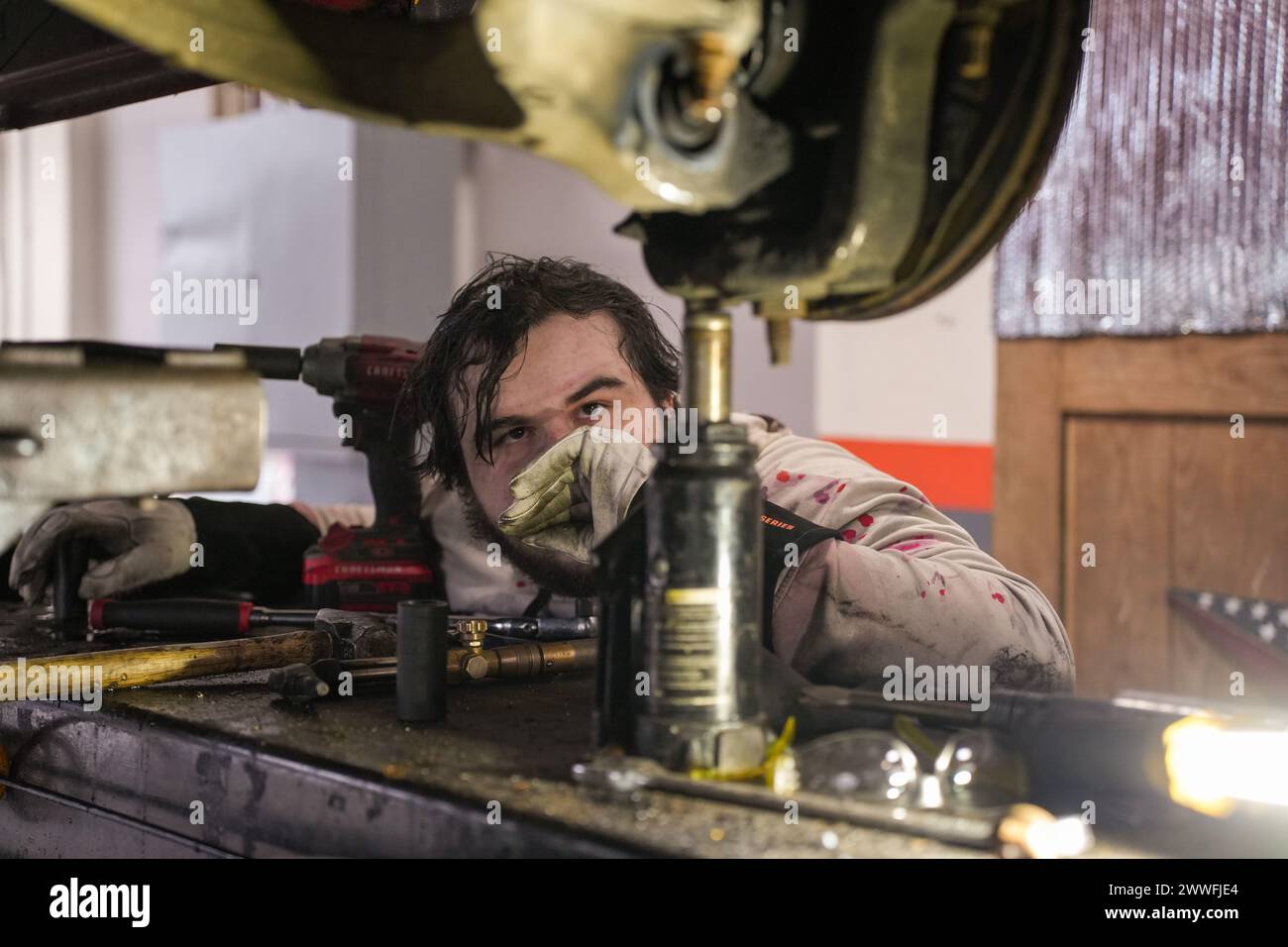 Mechanic assessing the lower control arm of a vehicle suspension Stock ...