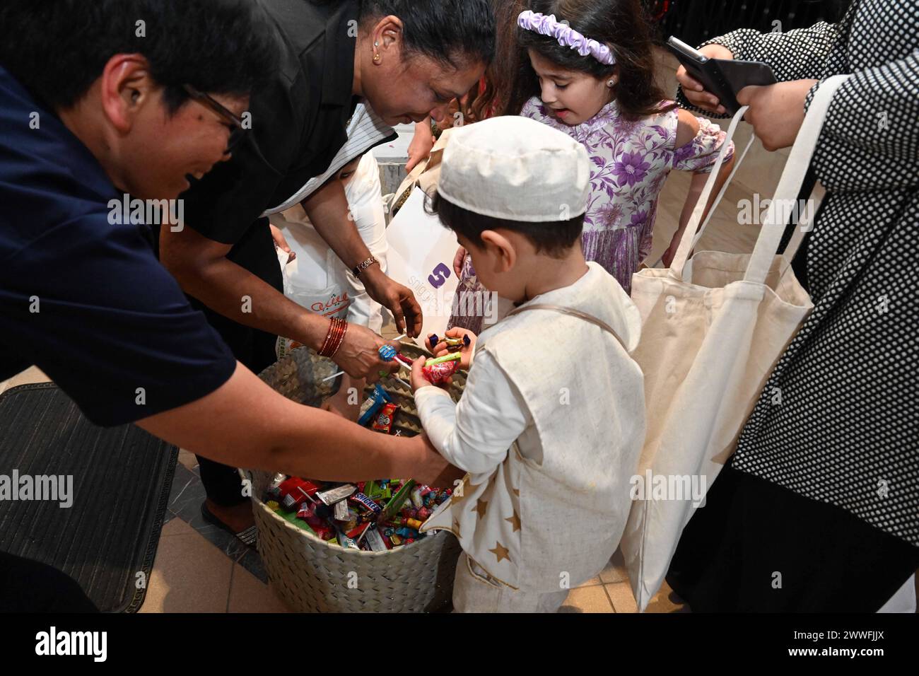 Hawalli Governorate, Kuwait. 23rd Mar, 2024. Children receive sweets ...