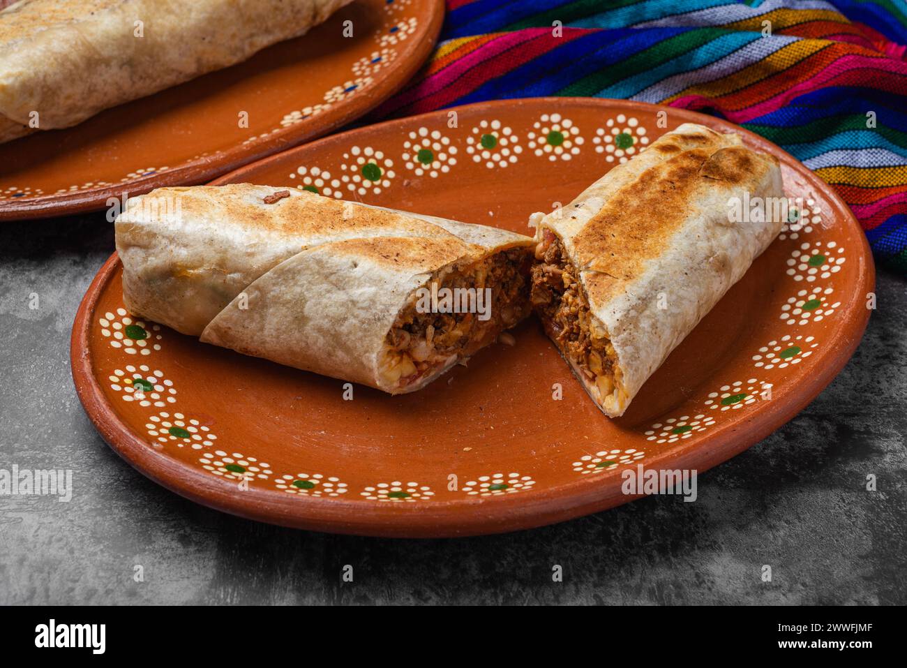 Mexican burrito cut on a clay plate. Mexican fast food Stock Photo - Alamy