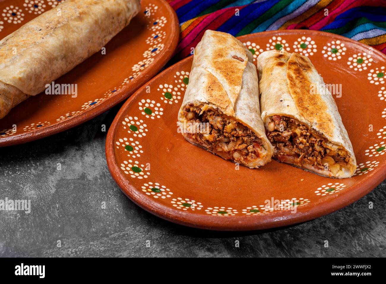 Mexican burrito cut on a clay plate. Mexican fast food Stock Photo - Alamy