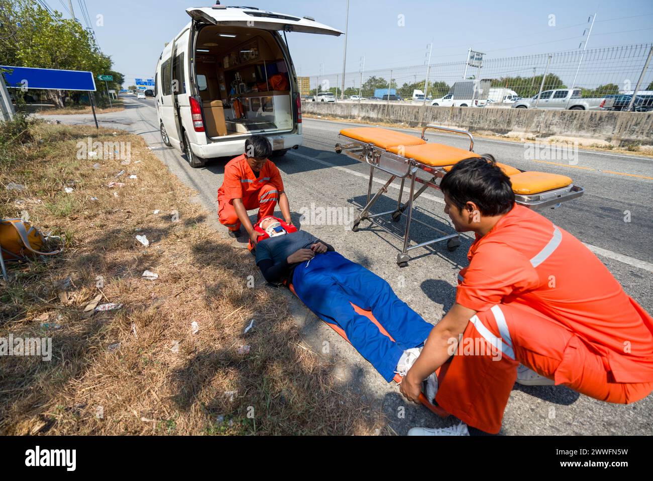 Two paramedic or emergency medical technician (EMT) in orange uniform ...