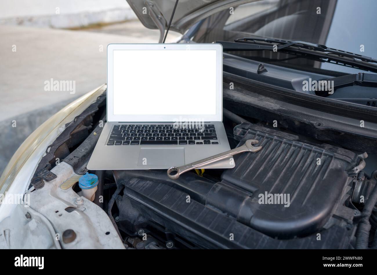 A blank screen laptop computer and wrench tool placing inside car's ...