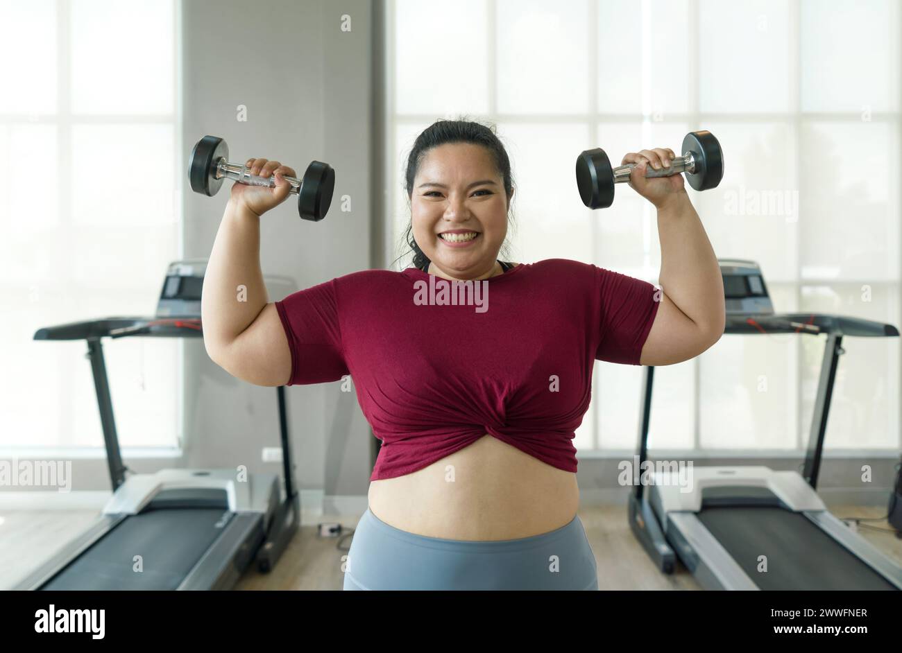 Asian plus-sized woman lift weight at gym, getting strong and healthy ...