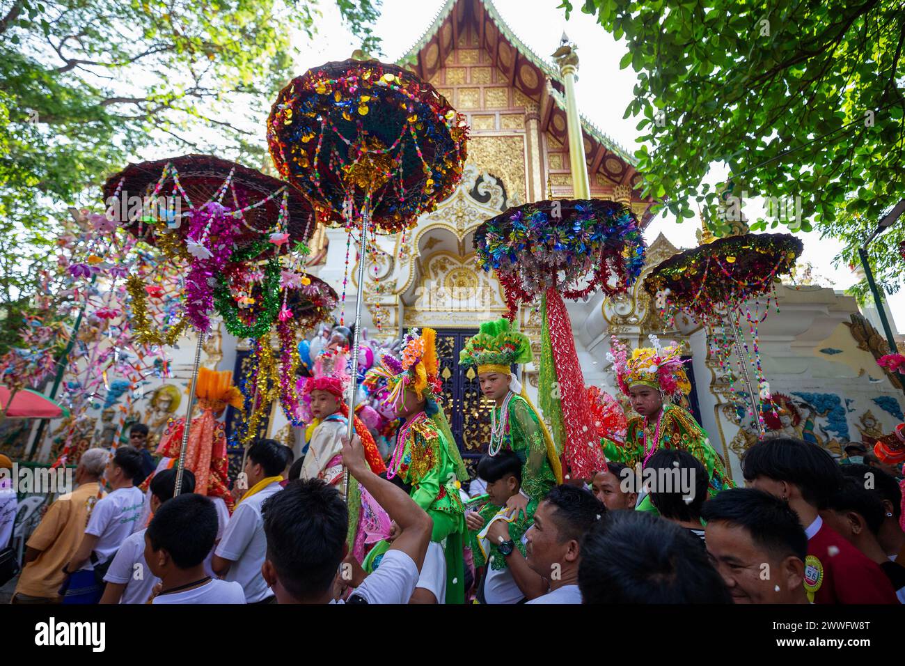 Young ethnic Shan boys dressed in colorful costumes are being carried ...