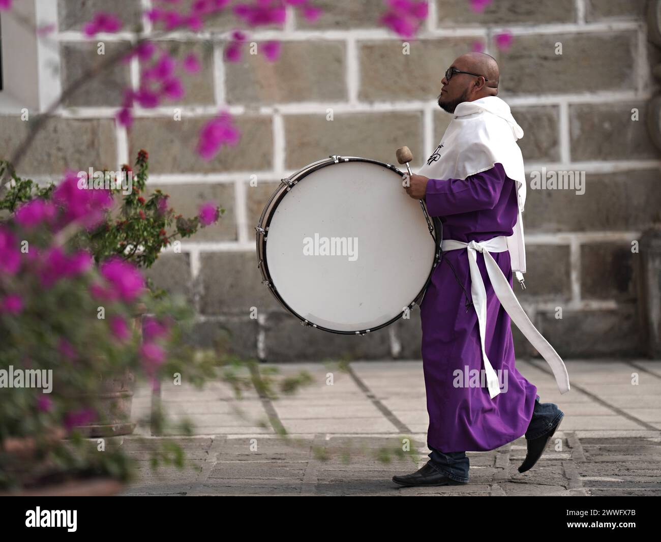 Antigua, Guatemala. 23rd Mar, 2024. A penitent carries a bass drum into ...