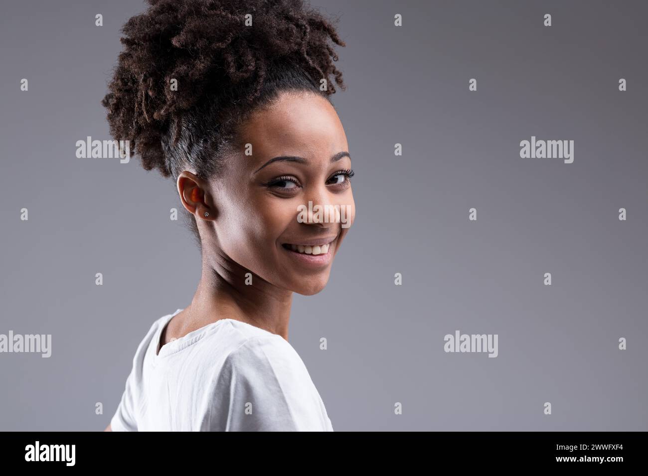 Enthralling smile of a young woman, her eyes twinkling with mirth ...