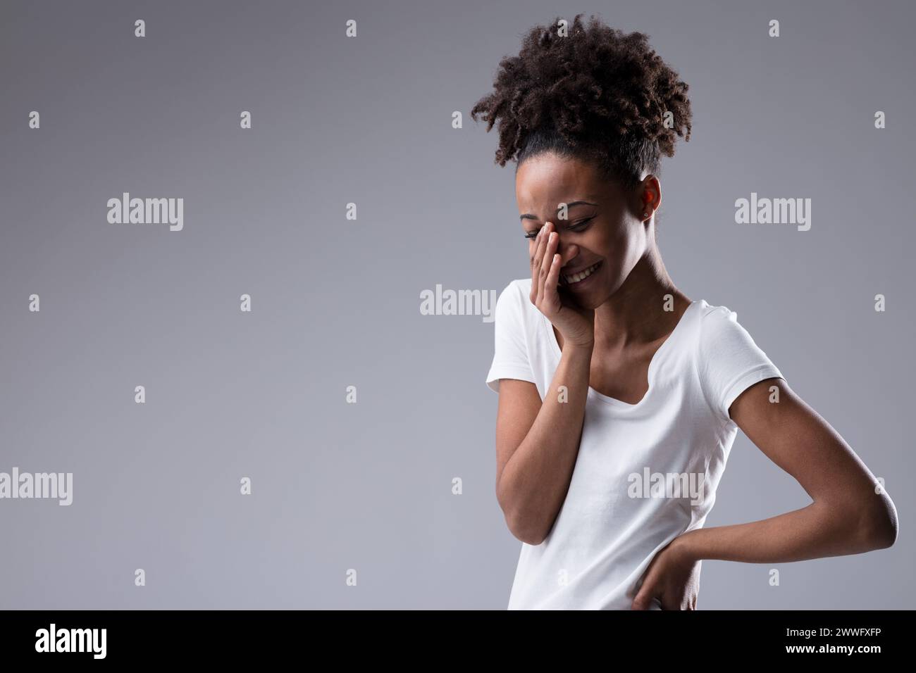 woman's heartfelt laughter captured candidly as she playfully hides her ...