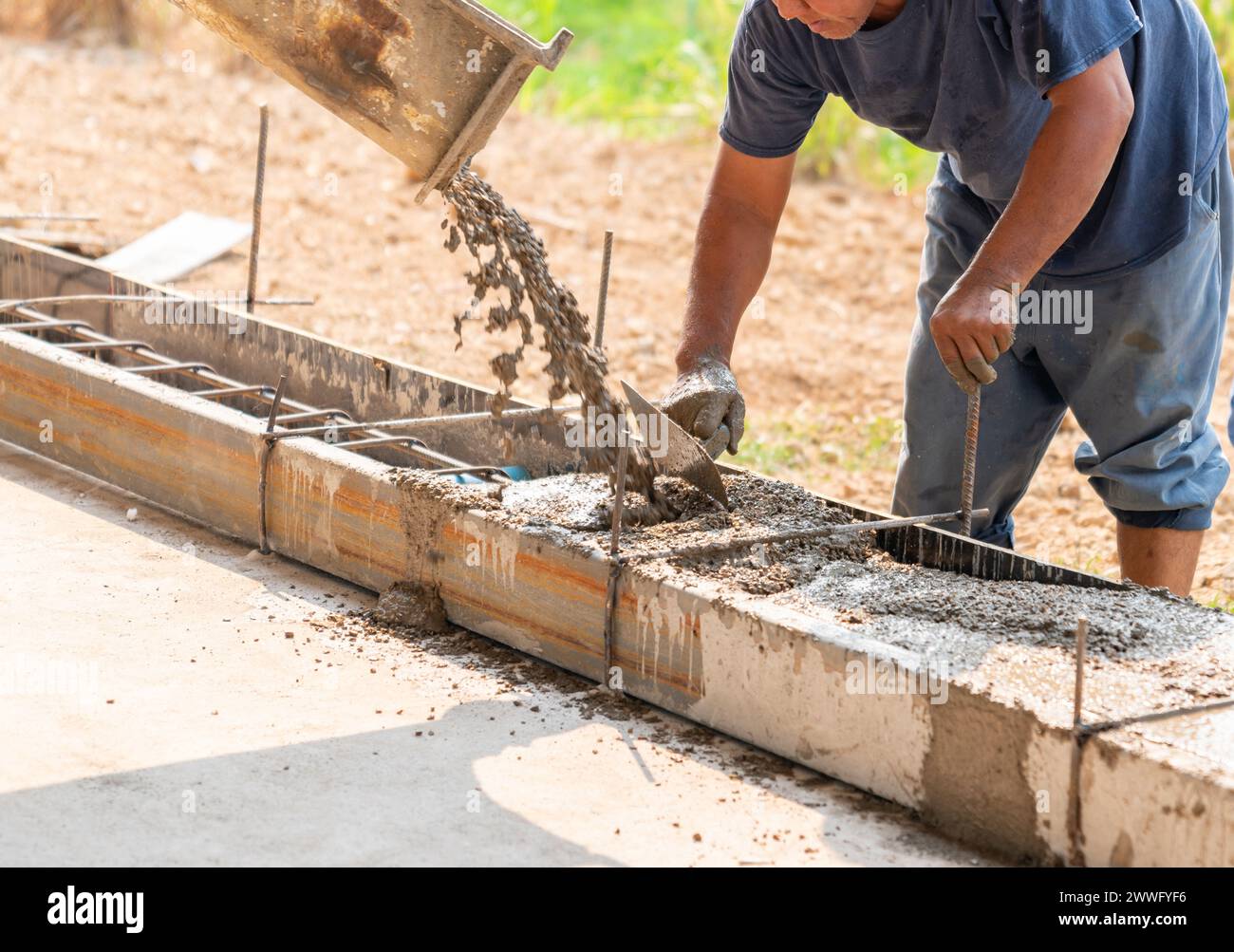 After pouring concrete worker uses trowel to plaster wet concrete ...