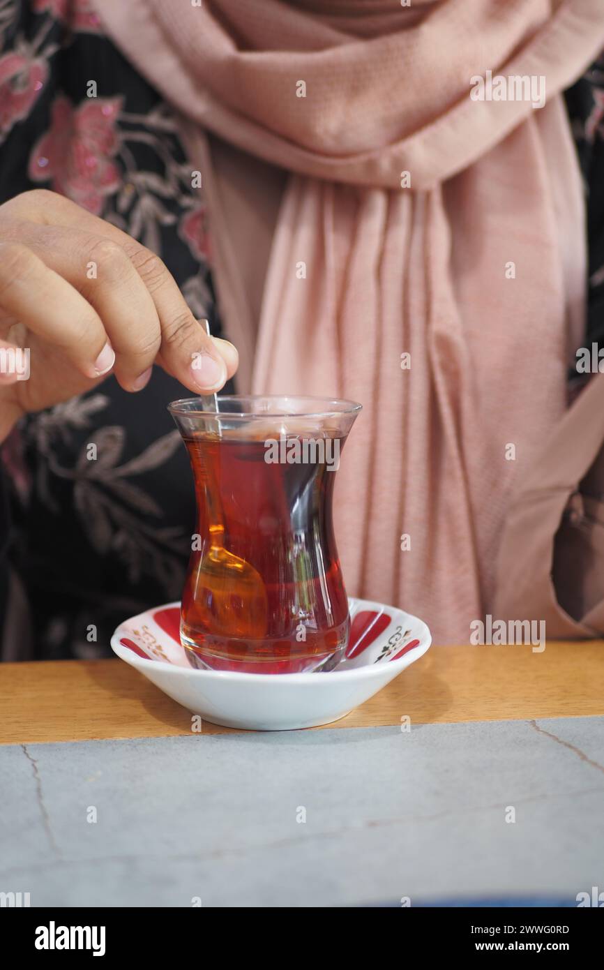 woman drinking Traditional turkish tea on white table Stock Photo - Alamy