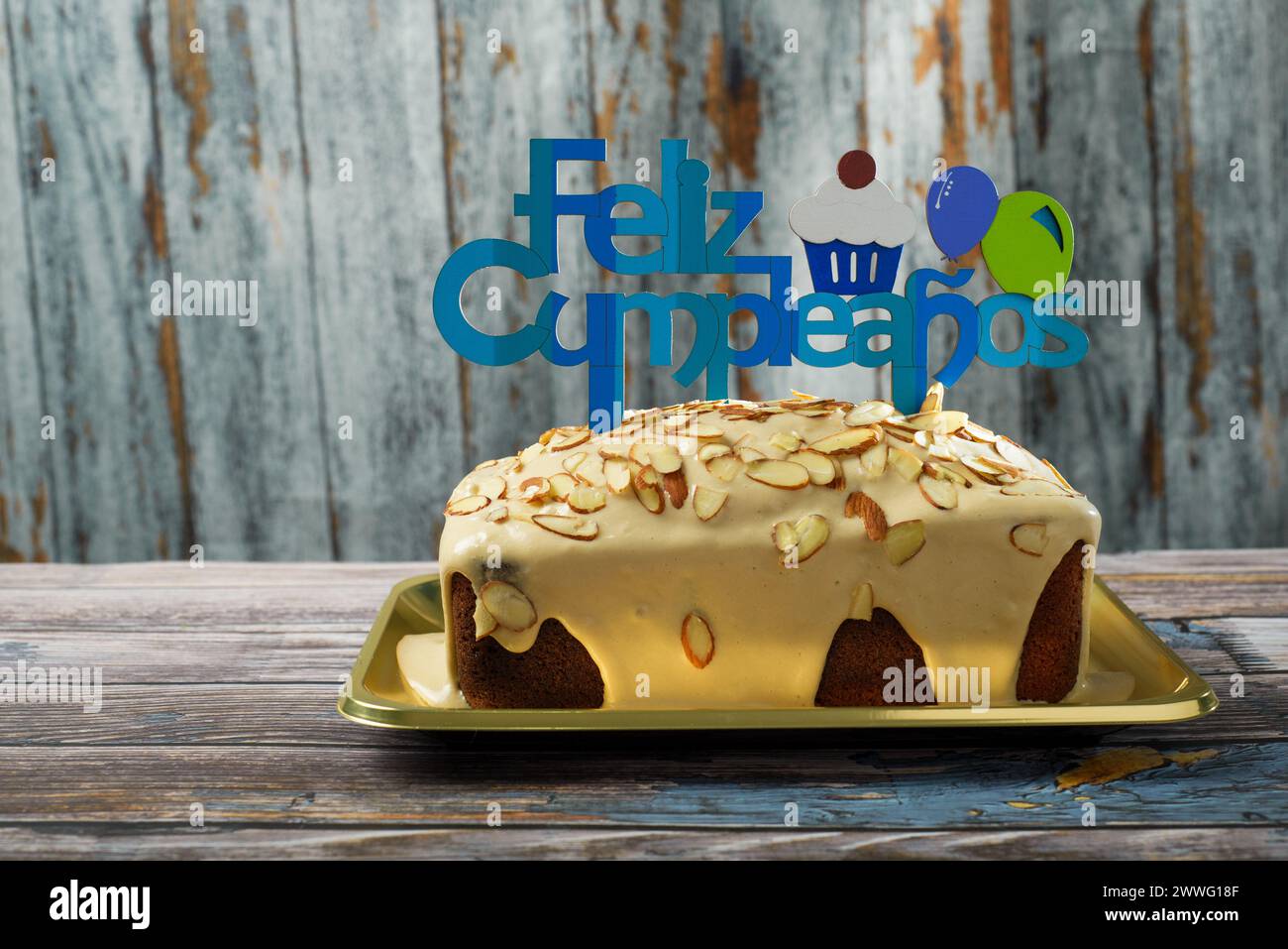 Small cake decorated with almond flakes with Happy Birthday topper in ...