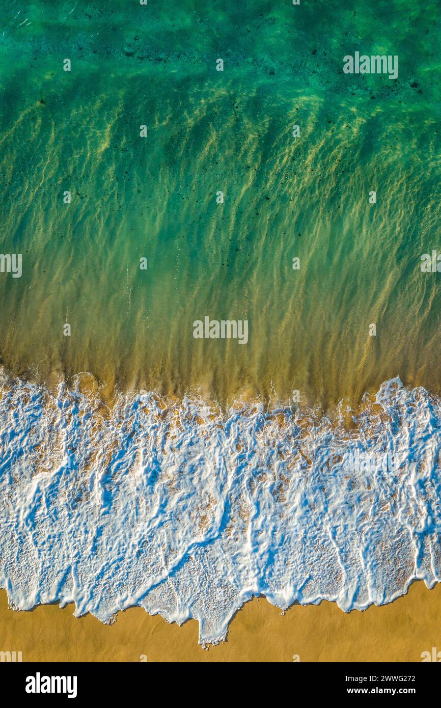 Low overhead drove view of a wave breaking on the beach at Sandy beach ...