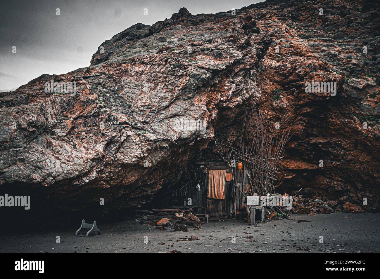A rugged, cliffside shack overlooking a beach, offering a rustic escape ...