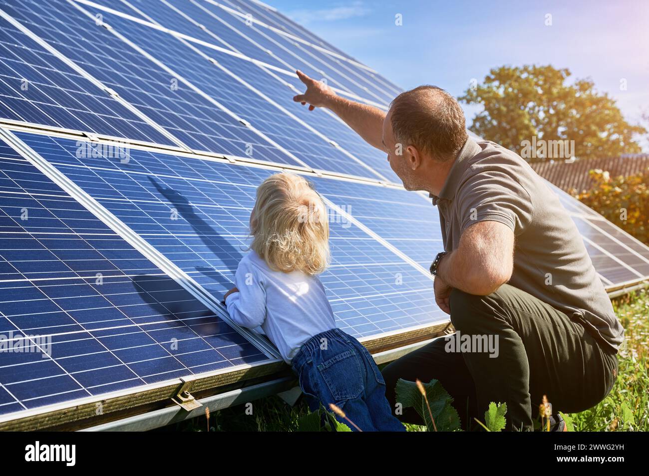 Man showing his son solar panels during sunny day. Father presentng to ...