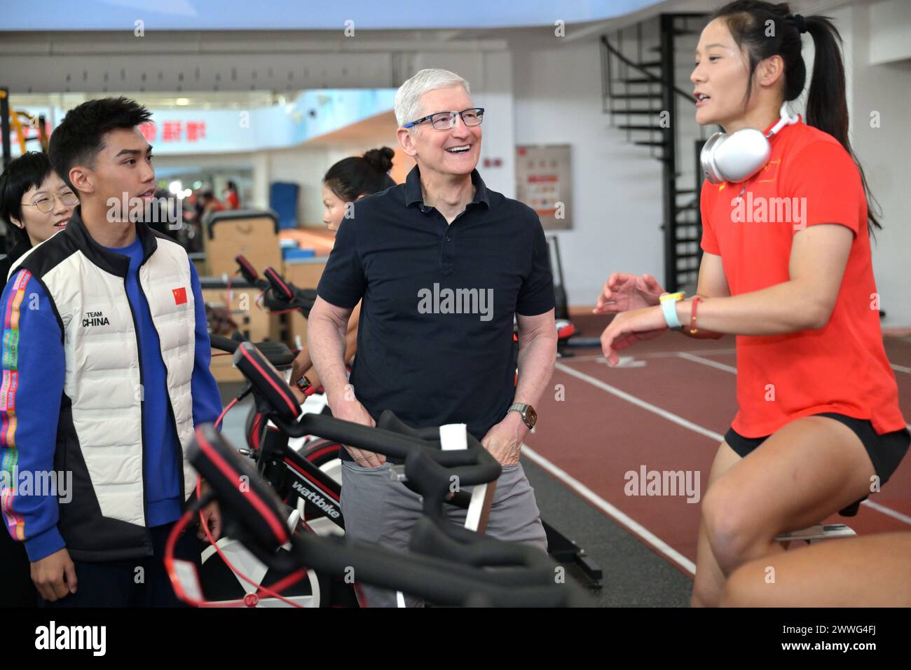 Beijing, China. 23rd Mar, 2024. Apple CEO Tim Cook (C) chats with ...