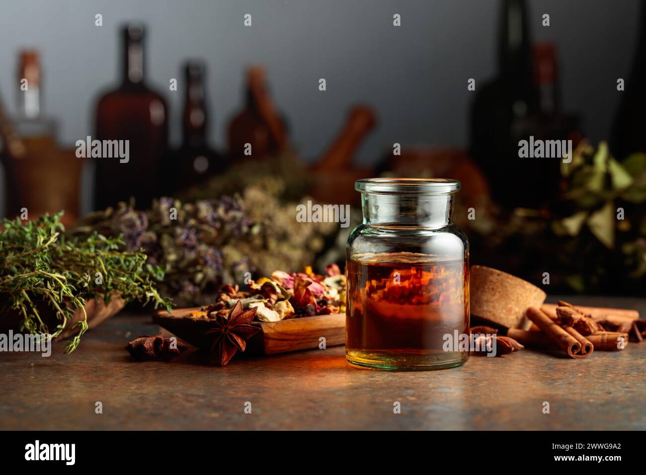 Essential herbal tincture in a small glass bottle. On a table dried ...