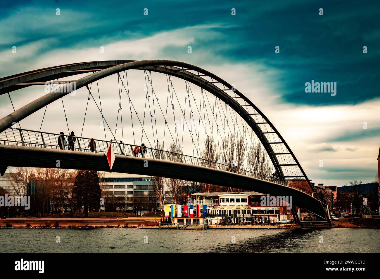 Warm sunset hues cast over a sleek pedestrian bridge Stock Photo - Alamy