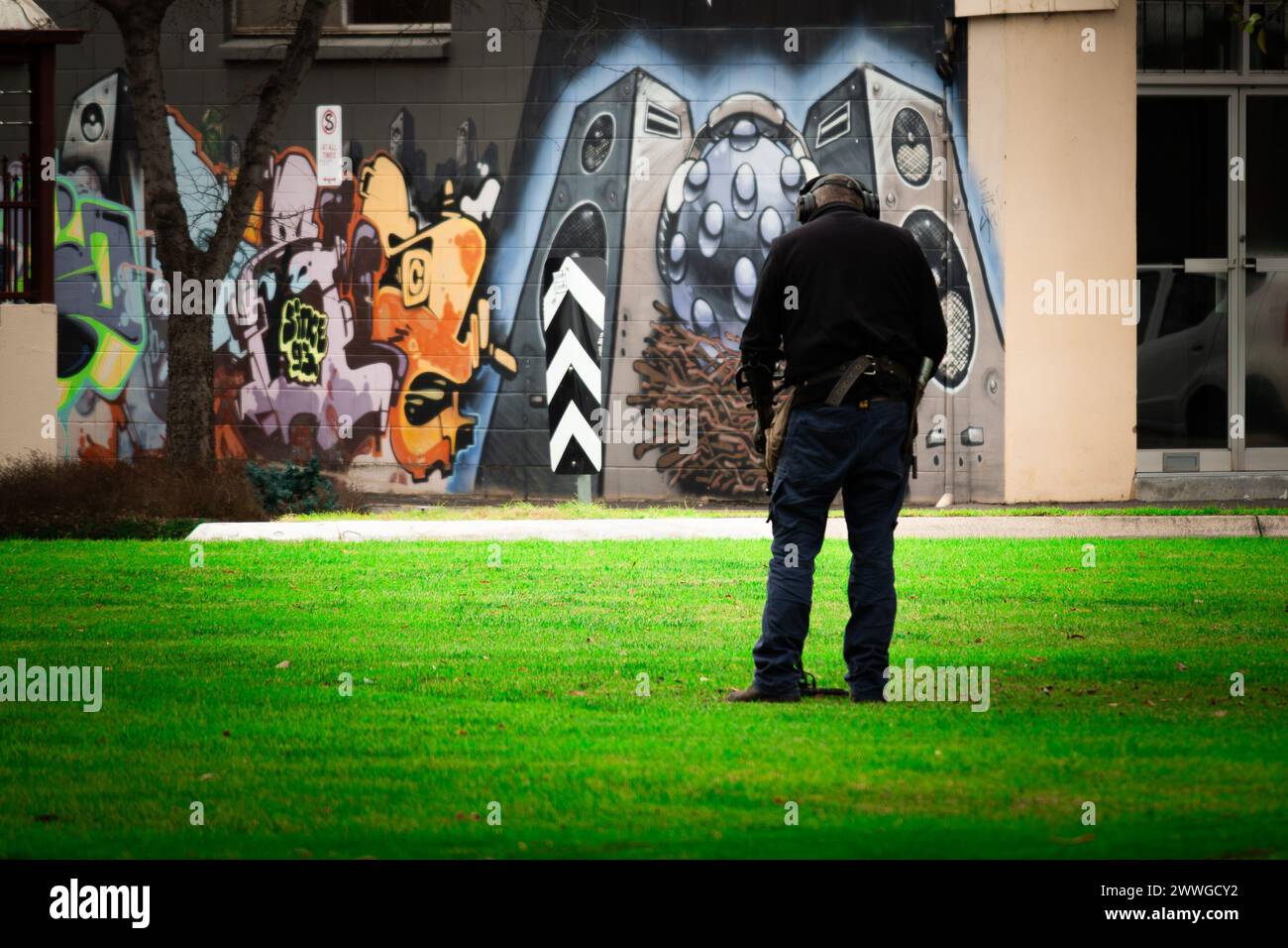 A man observes colorful urban graffiti, contemplating street art ...