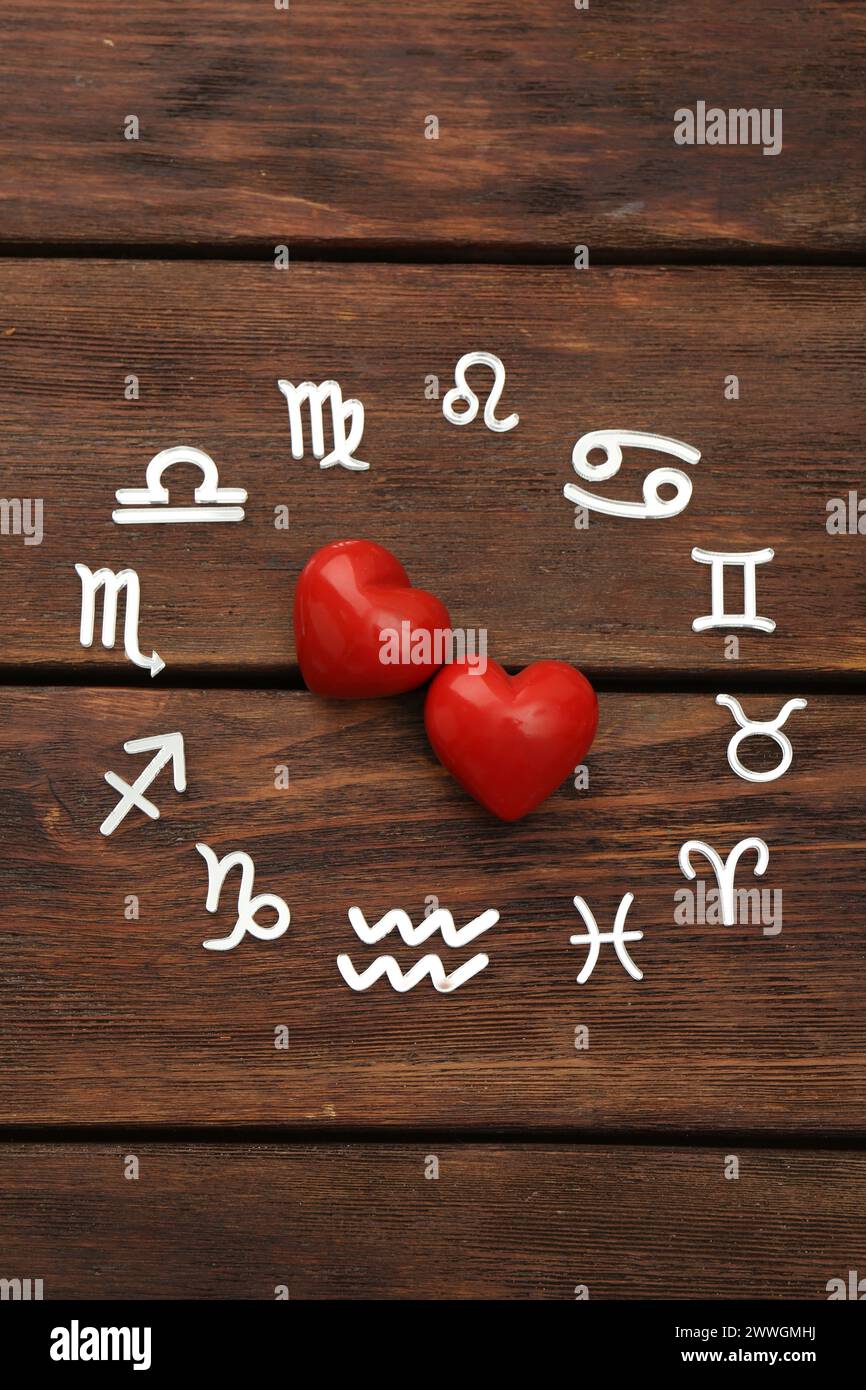 Zodiac signs and red hearts on wooden background, flat lay Stock Photo ...
