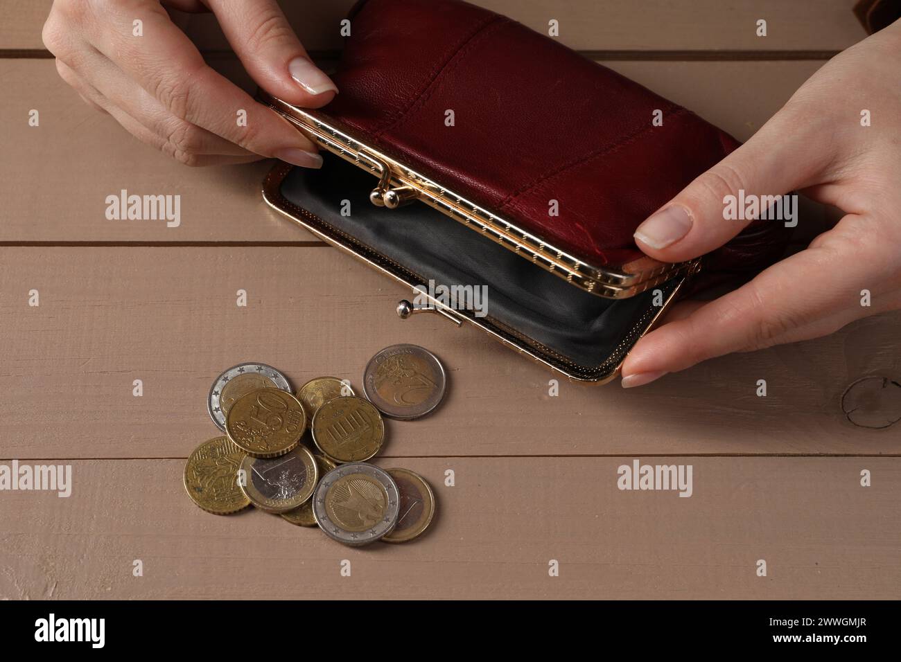 Poverty. Woman with empty wallet and coins at wooden table, above view ...