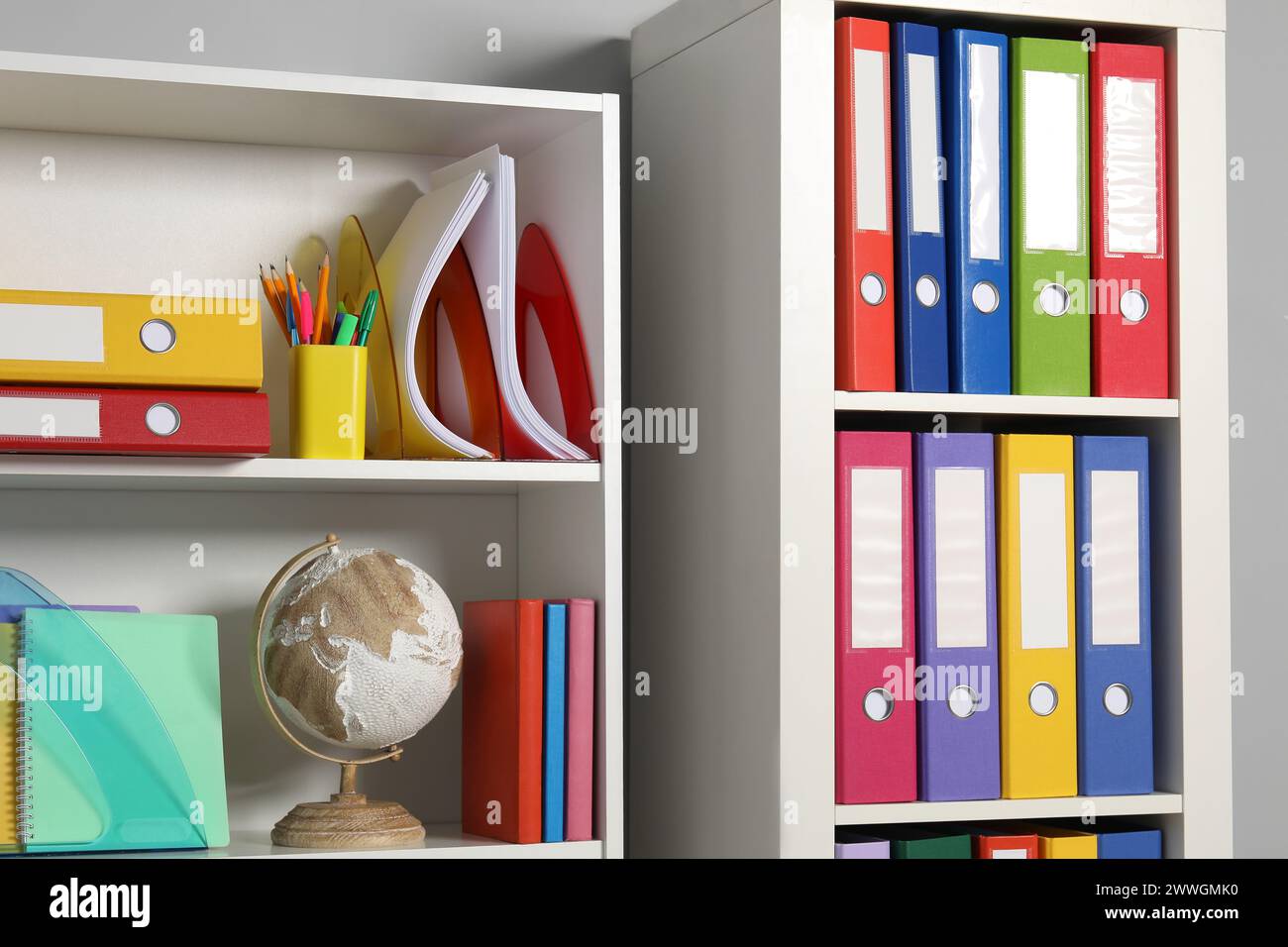 Colorful binder office folders and other stationery on shelving unit ...