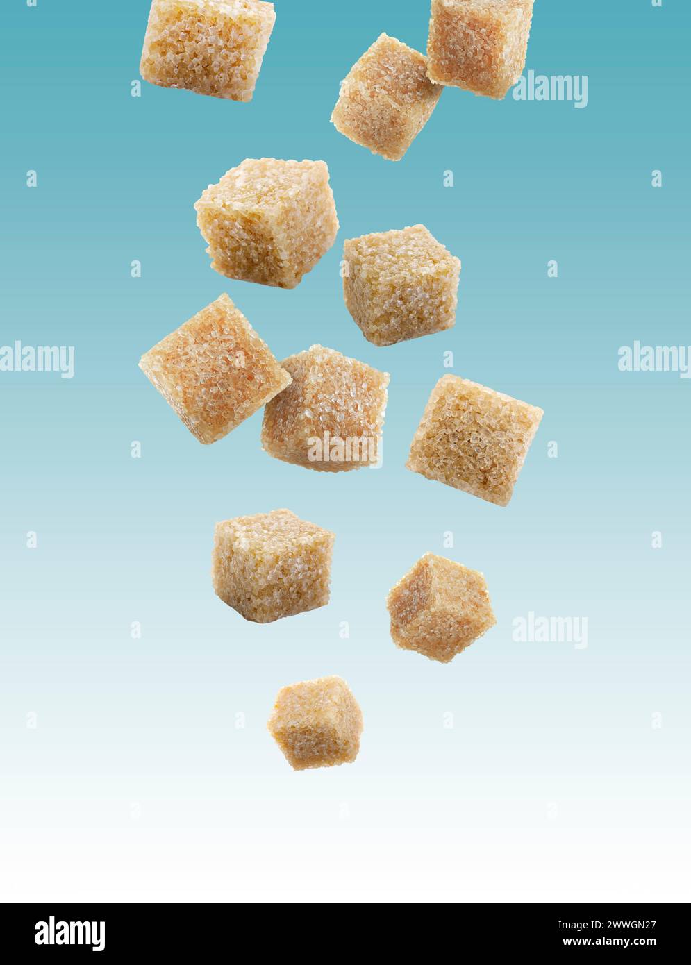 Brown cane sugar cubes falling on light blue gradient background Stock ...