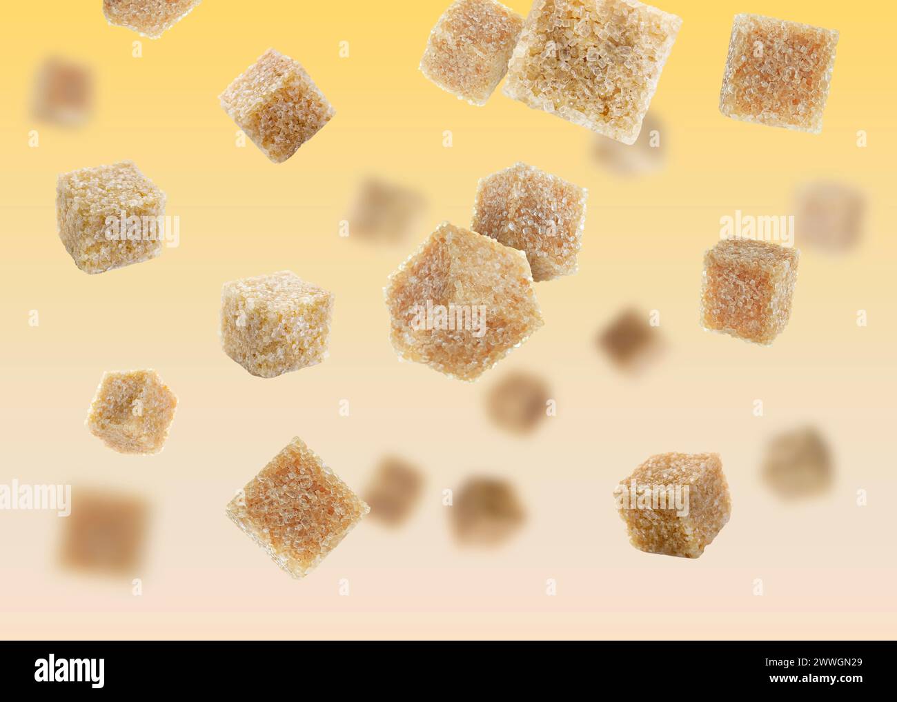 Brown cane sugar cubes falling on golden gradient background Stock ...