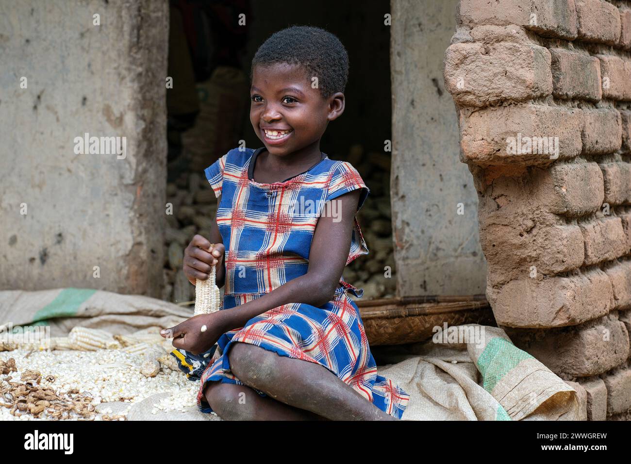 A child shelling maize cobs in the village of Manduwasa in the Machinga ...