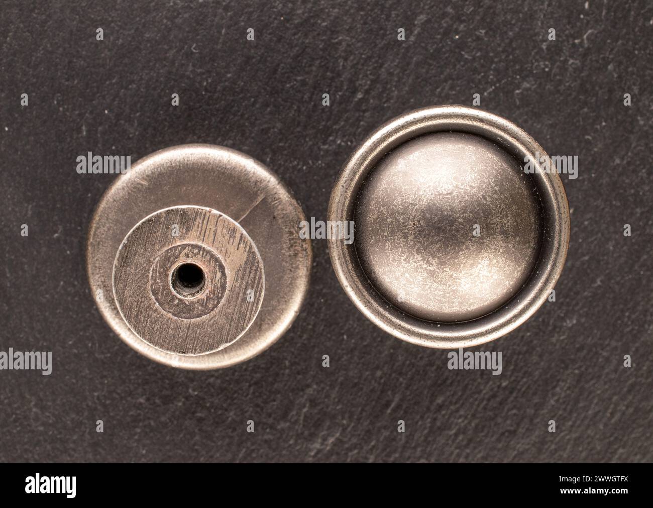 Two metal drawer handles on slate stone, furniture accessories, macro ...