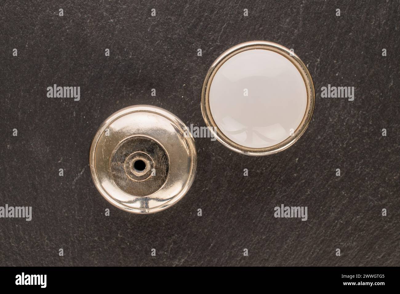 Two metal drawer handles on slate stone, furniture accessories, macro ...