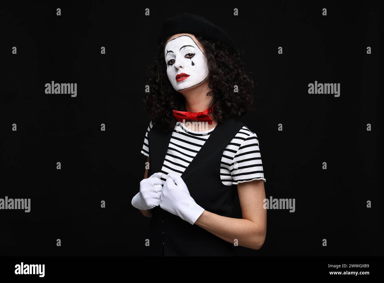 Young woman in mime costume posing on black background Stock Photo - Alamy