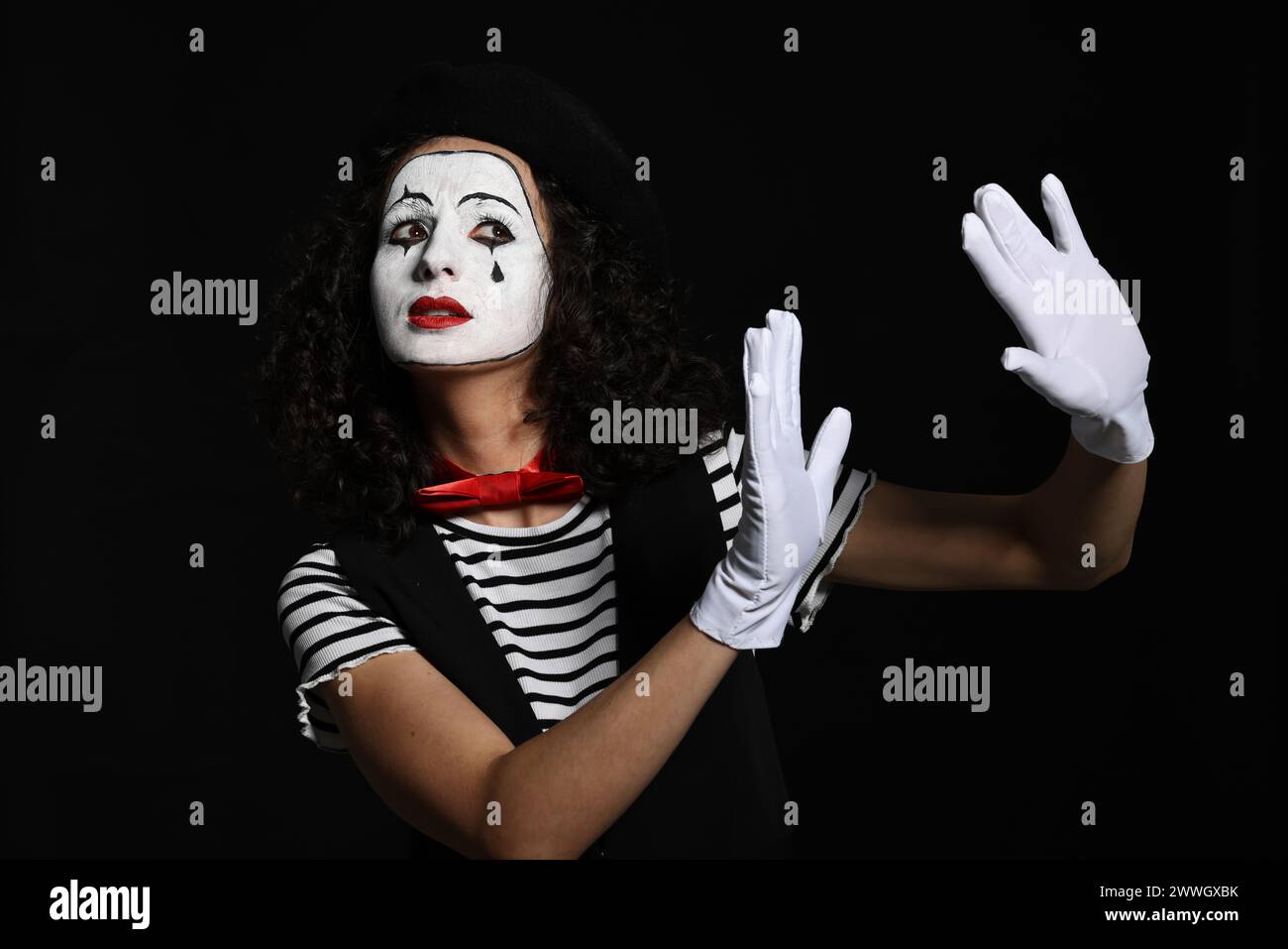 Young woman in mime costume posing on black background Stock Photo - Alamy