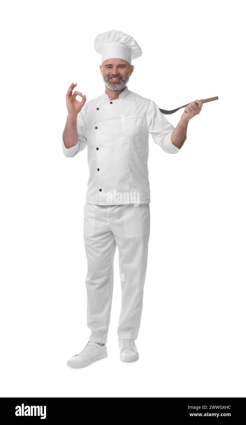 Happy chef in uniform with spoon showing OK gesture on white background ...