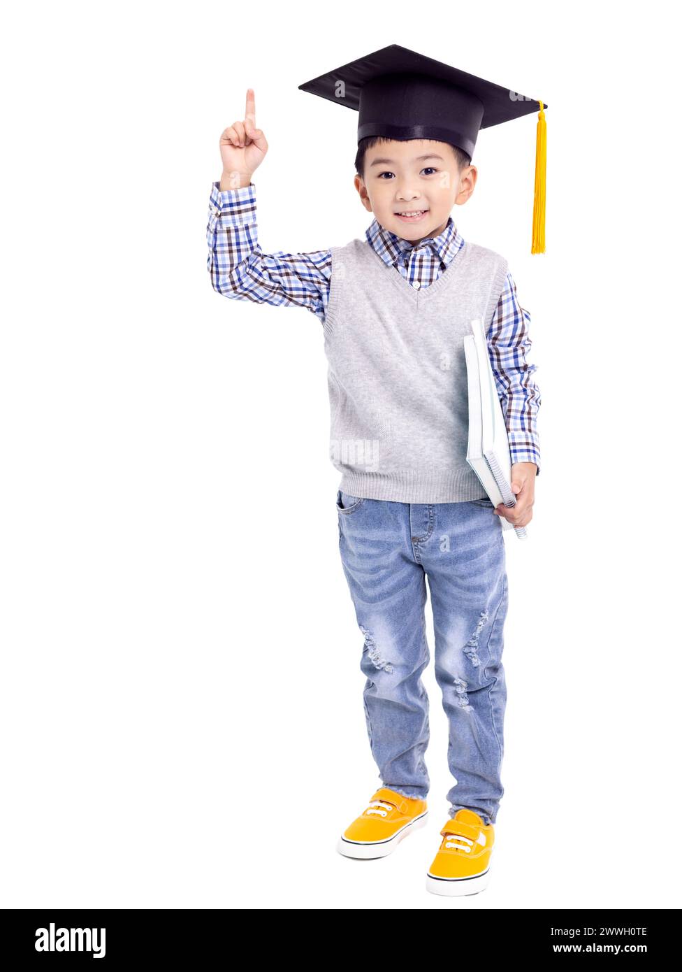 Happy Asian school kid graduate in graduation cap and hand pointing up ...